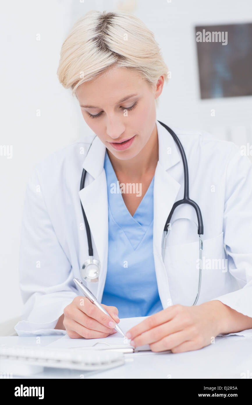 Doctor writing prescription at table Stock Photo - Alamy