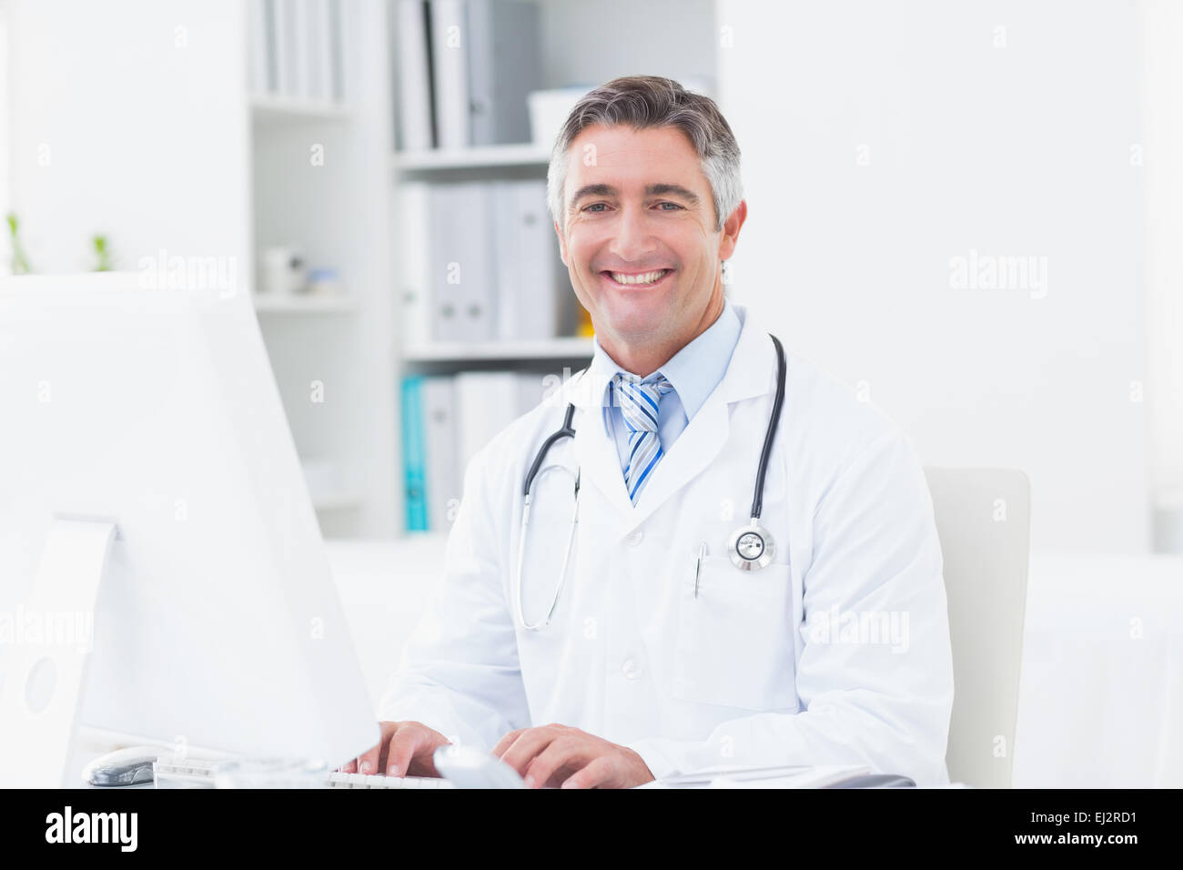 Confident doctor using computer in clinic Stock Photo - Alamy