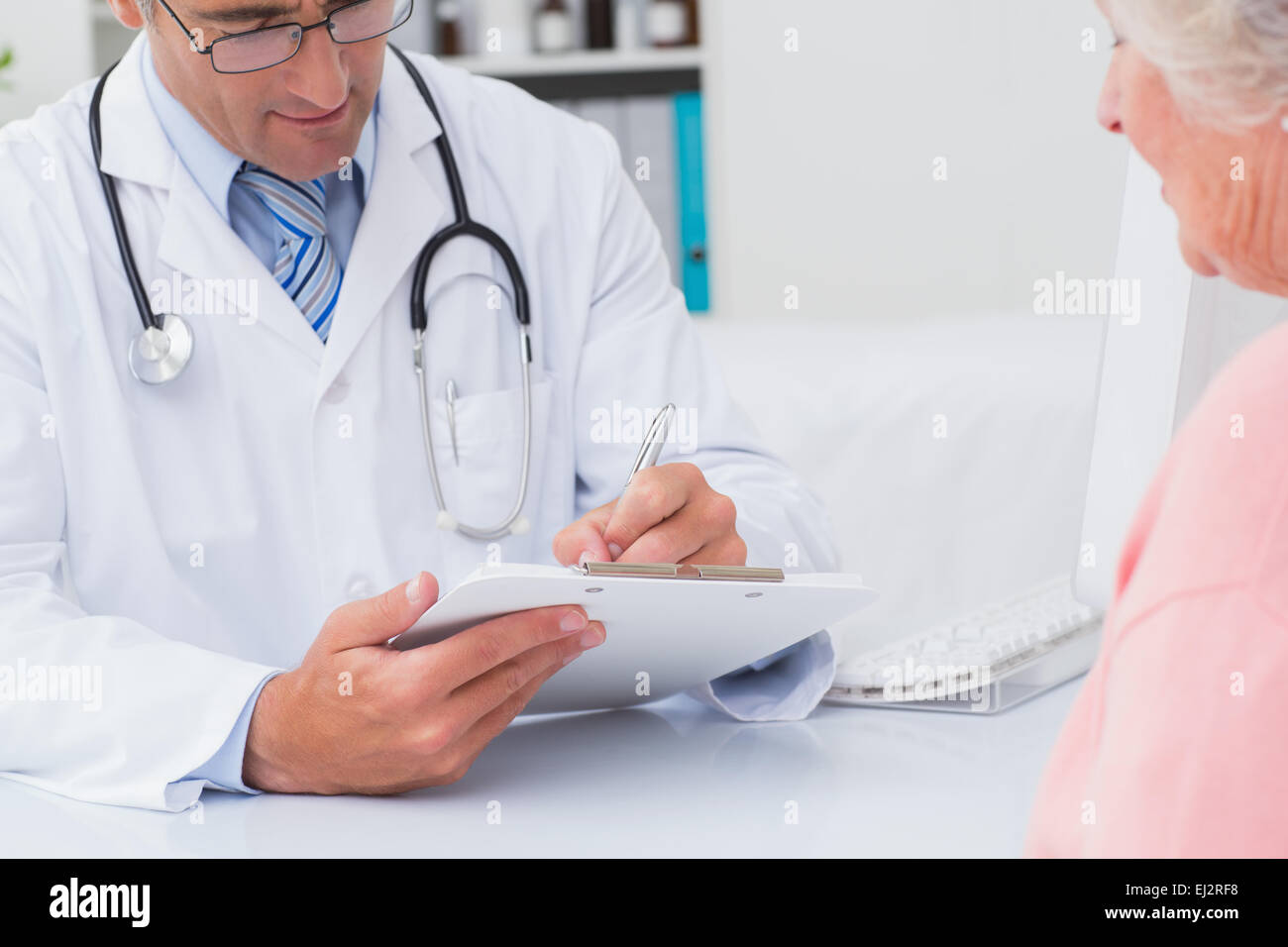 Male doctor writing prescriptions for female patient Stock Photo - Alamy