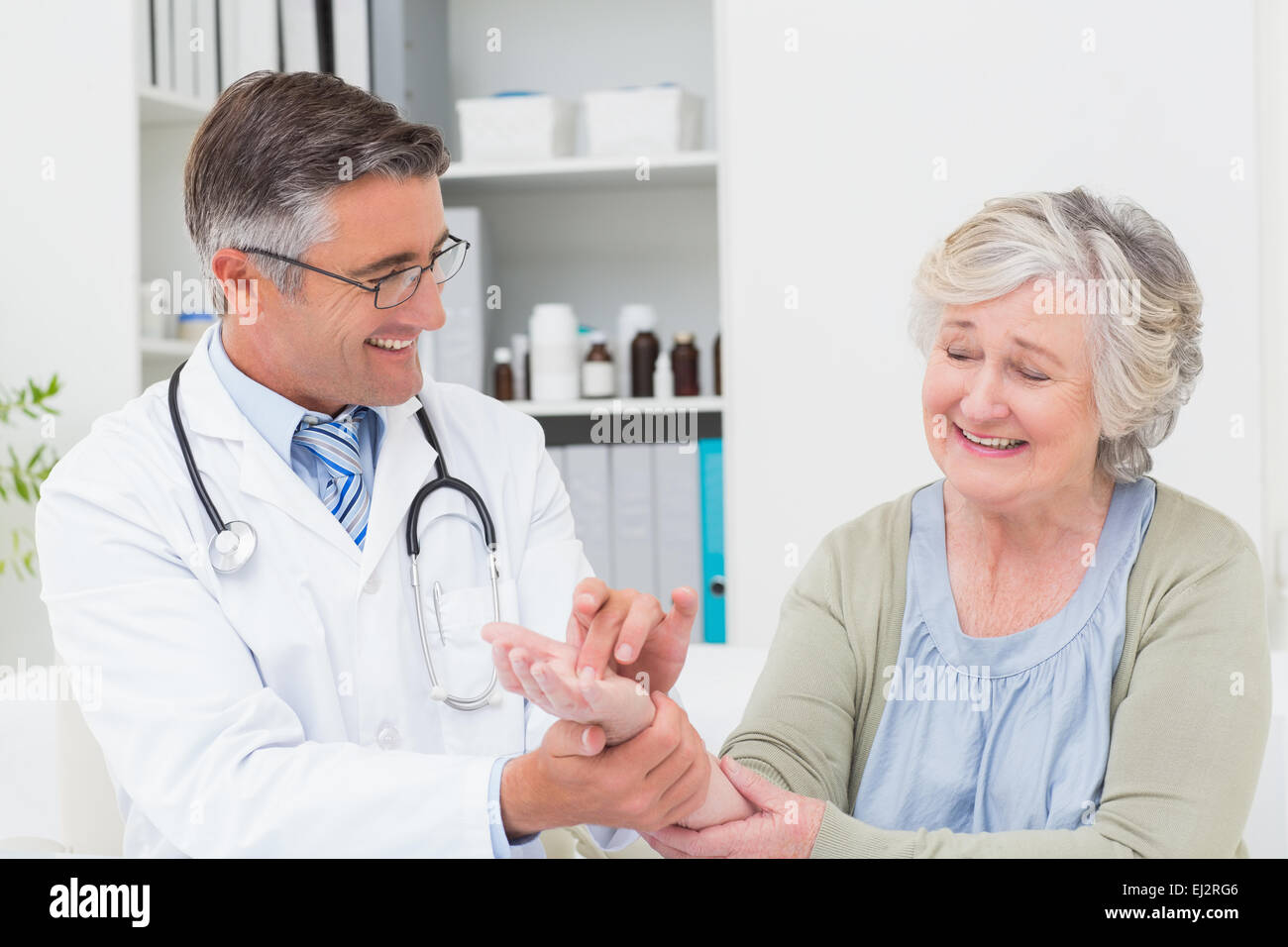 Male doctor examining patients hand at table Stock Photo - Alamy