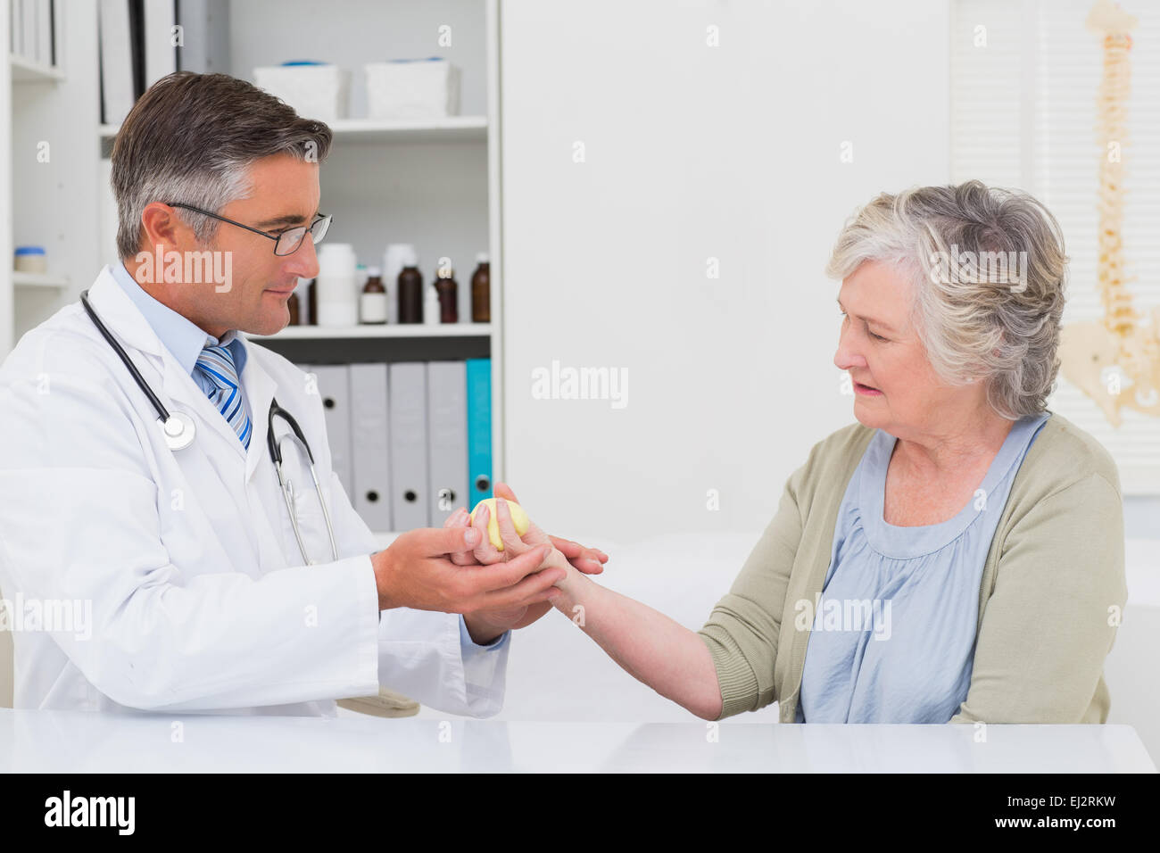 Male doctor assisting female patient to hold weight Stock Photo - Alamy