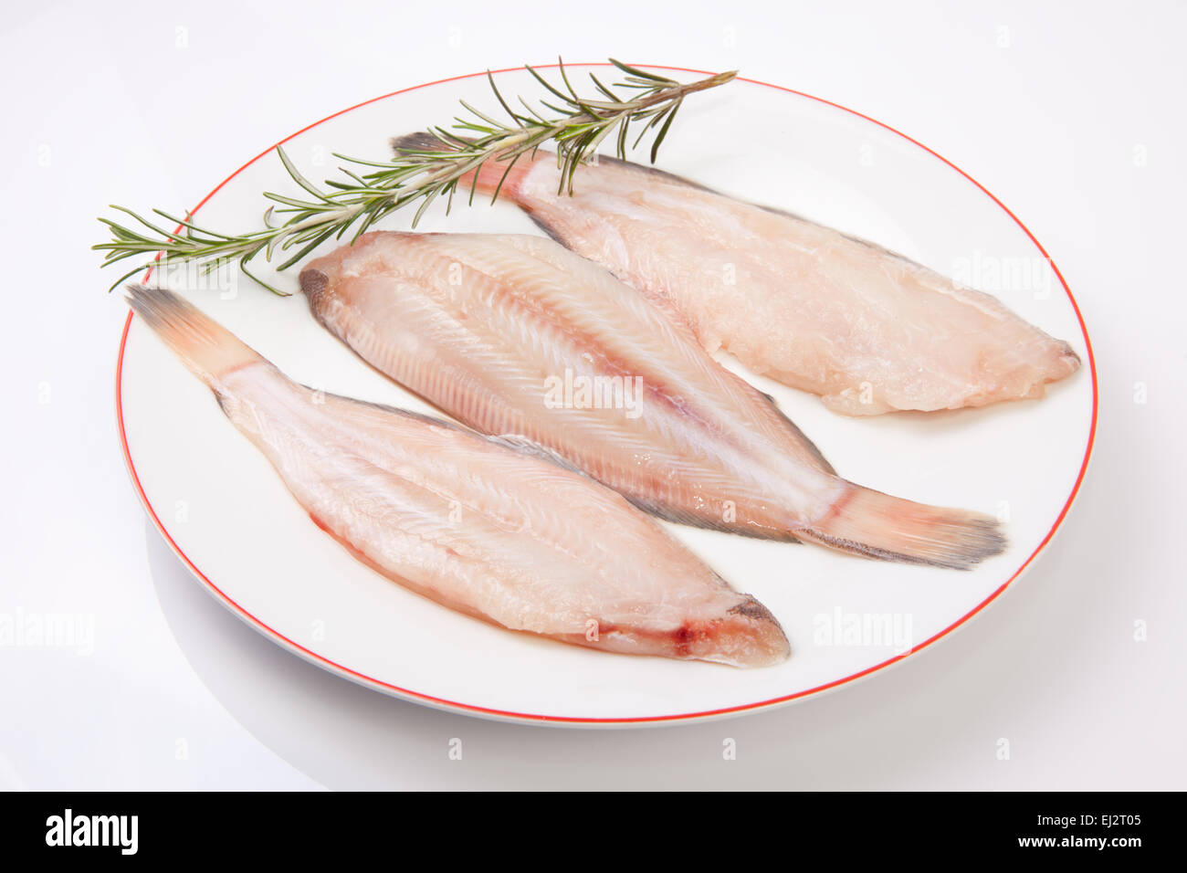 Raw sole fish ready to cook. Plate of three pieces decorated with a ...