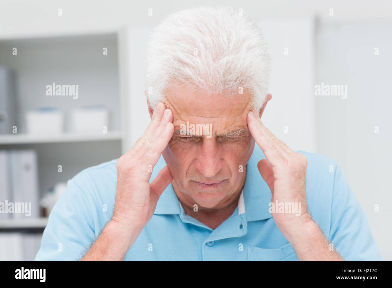Tensed male patient suffering from headache relaxing on hospital bed ...