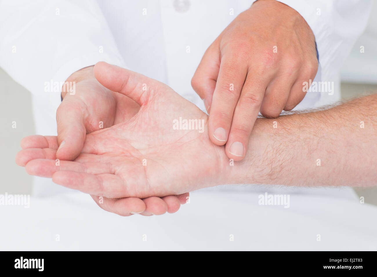 Doctor examining patients hand stethoscope hi-res stock photography and ...
