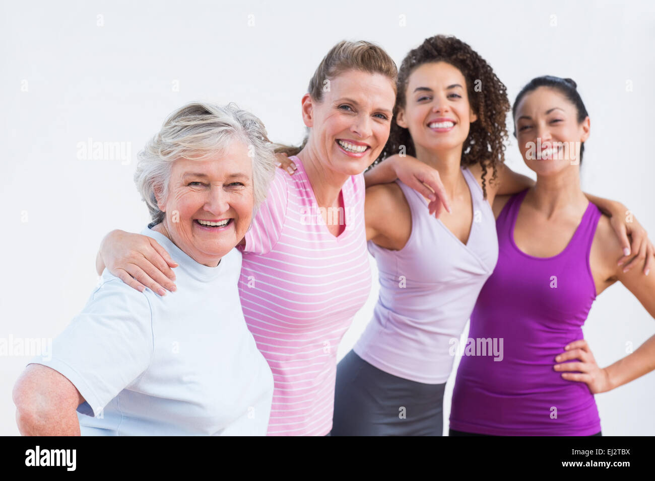 Happy friends standing arms around in fitness studio Stock Photo - Alamy