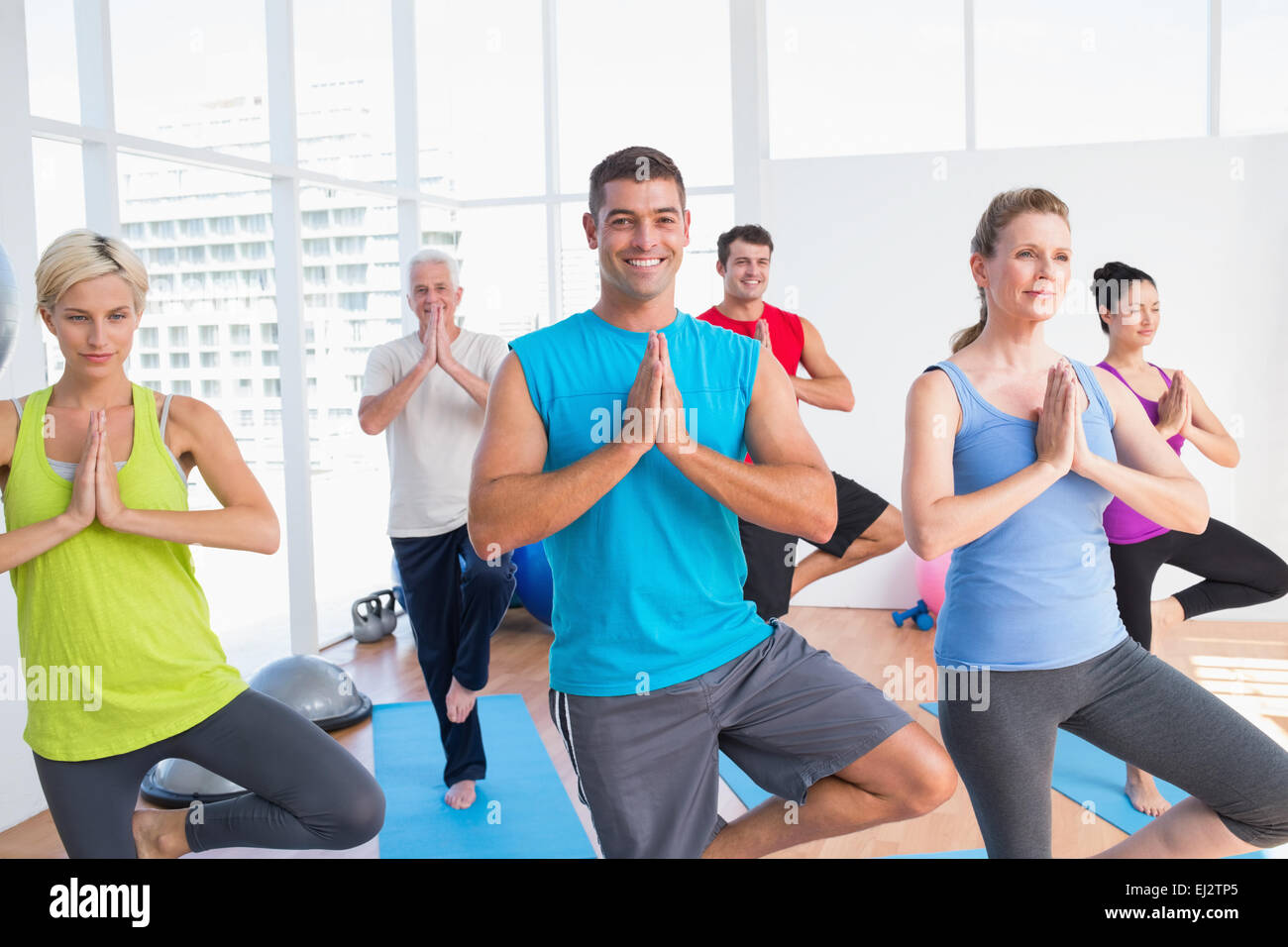 People practicing tree pose in fitness studio Stock Photo - Alamy