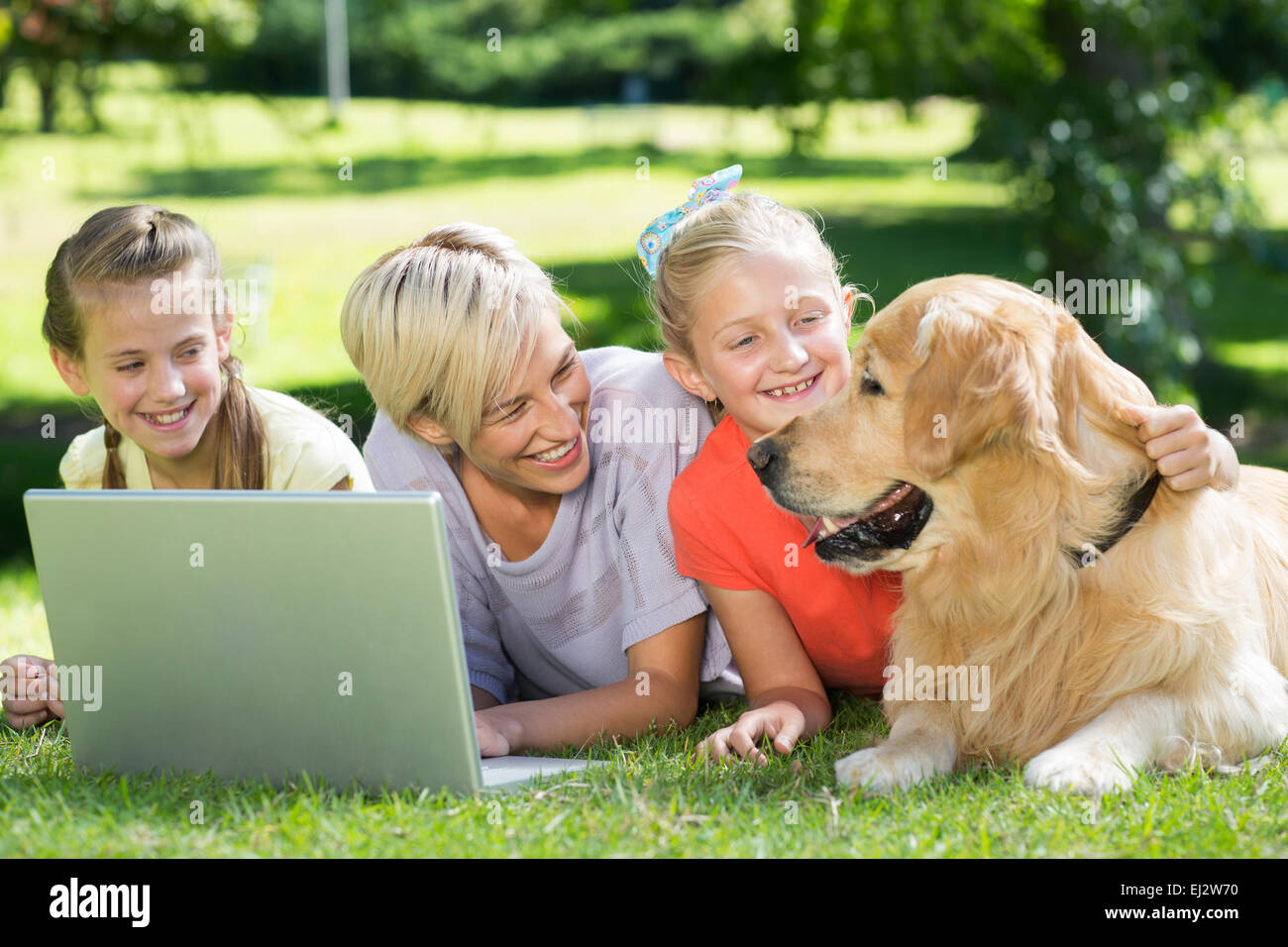 Happy family looking at their dog Stock Photo - Alamy