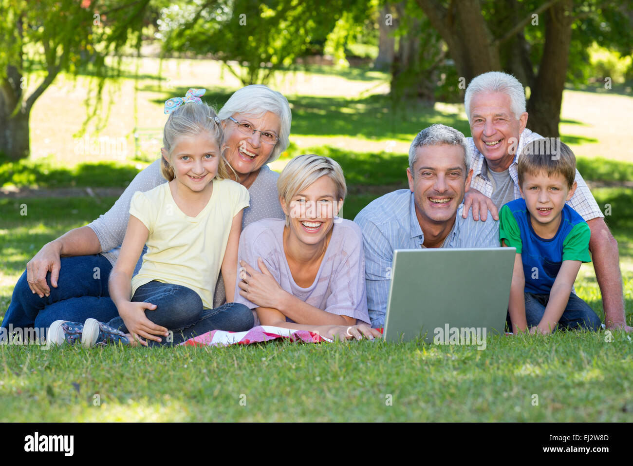 Happy family using laptop in the park Stock Photo - Alamy