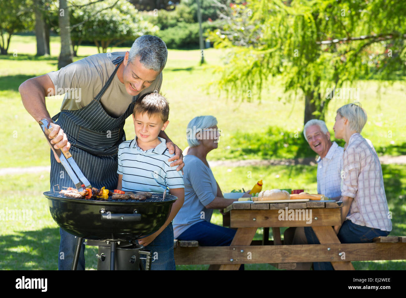 Happy father doing barbecue with his son Stock Photo - Alamy