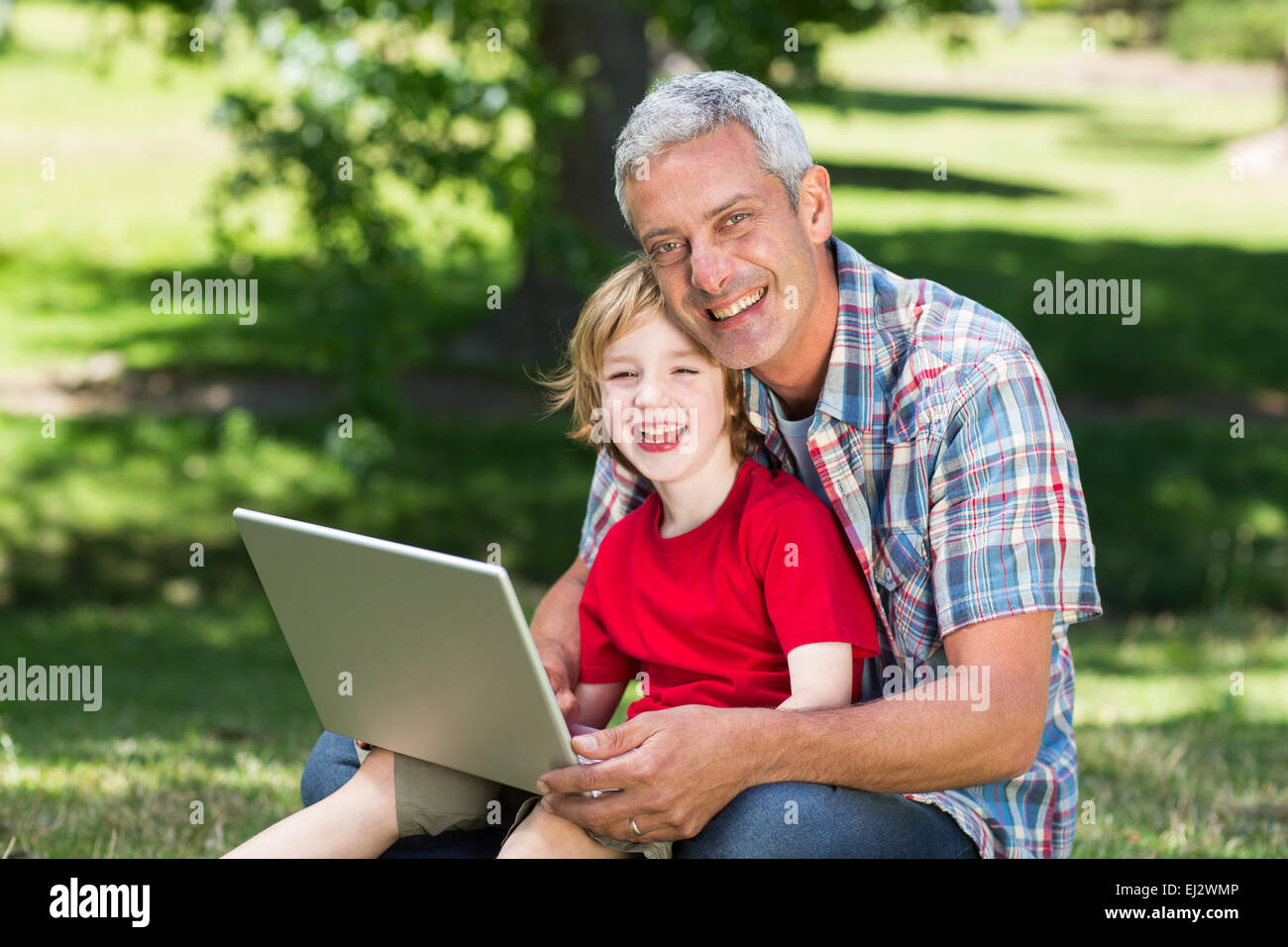 Happy father using laptop with his son Stock Photo - Alamy