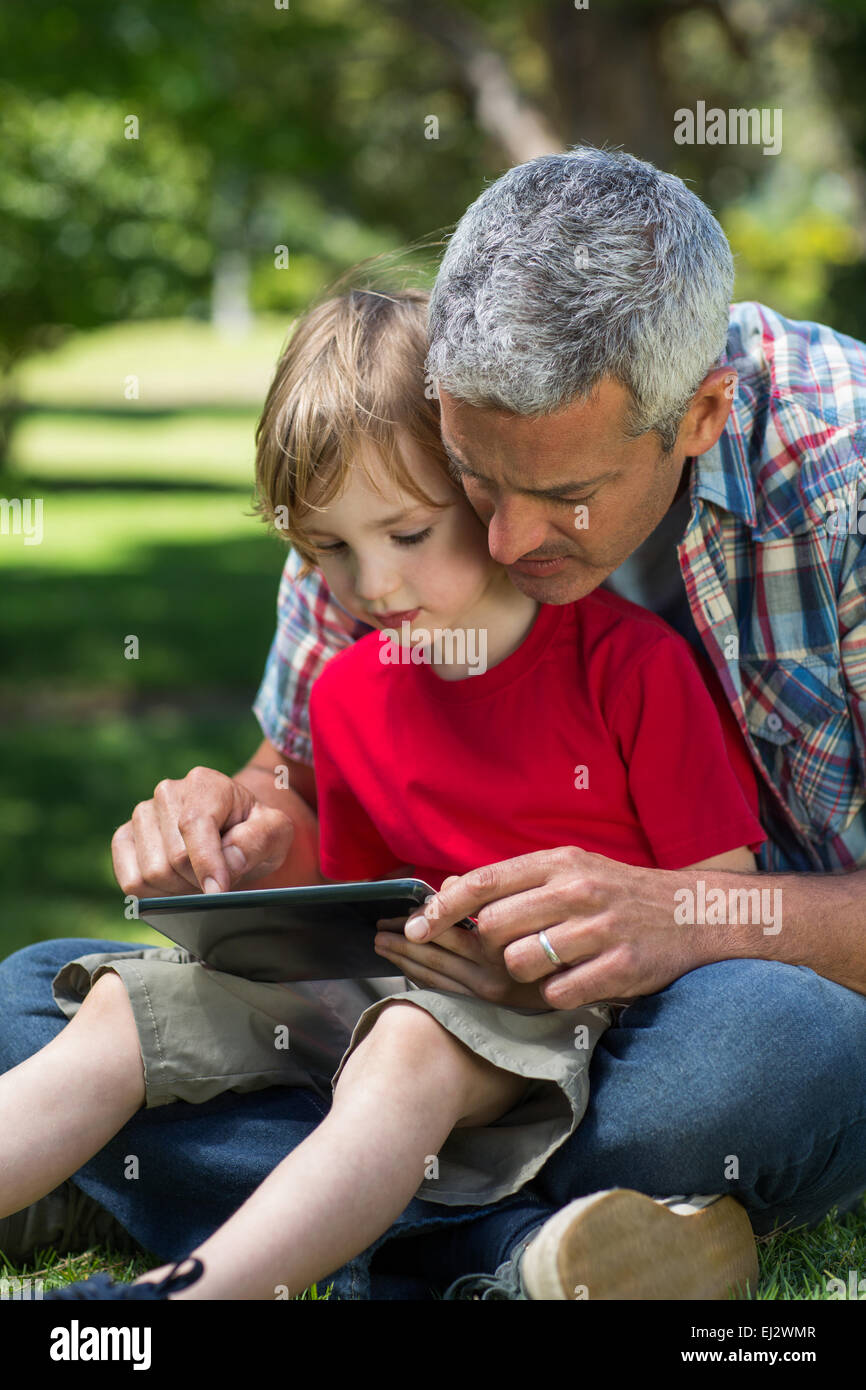 Happy father using tablet pc with his son Stock Photo - Alamy