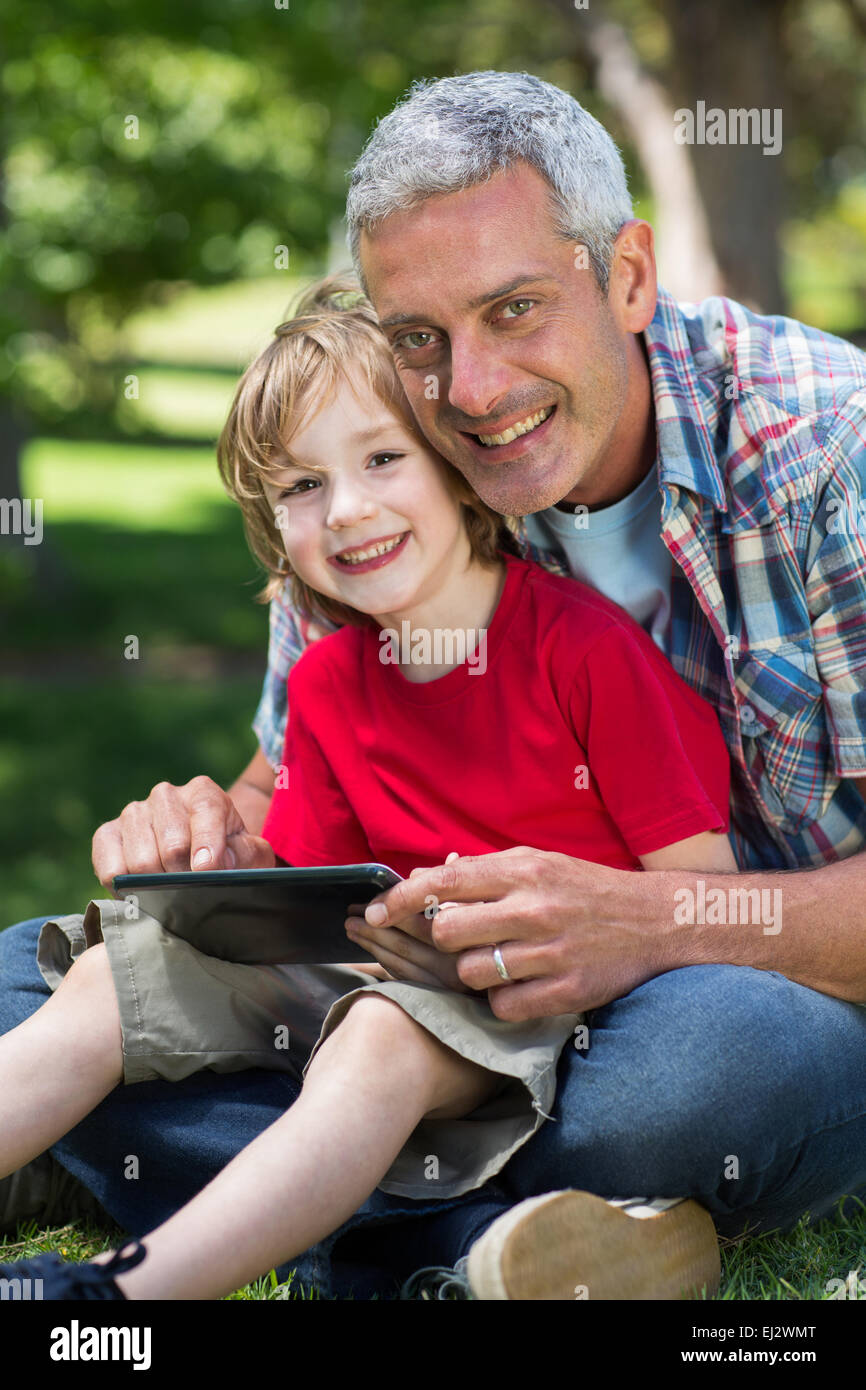 Happy father using tablet pc with his son Stock Photo - Alamy