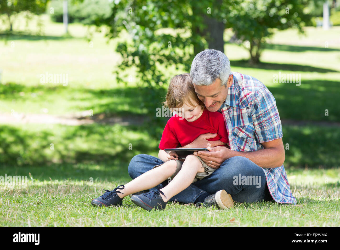 Happy father using tablet pc with his son Stock Photo - Alamy
