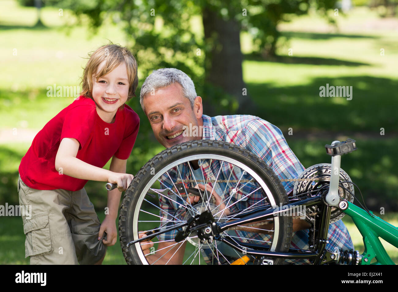 Happy father and his son fixing a bike Stock Photo - Alamy
