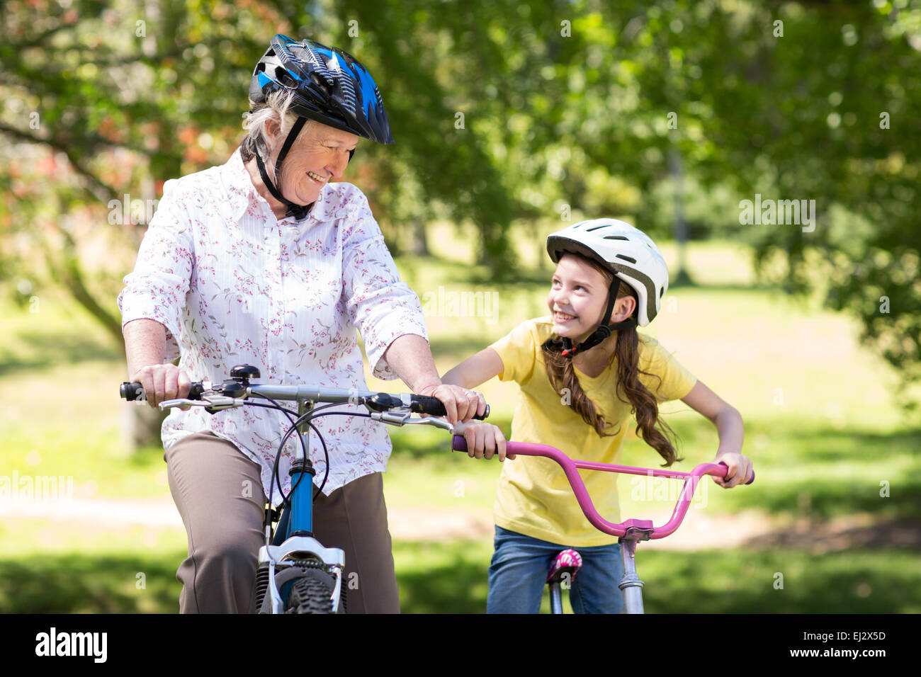 Happy grandmother with her granddaughter on their bike Stock Photo - Alamy