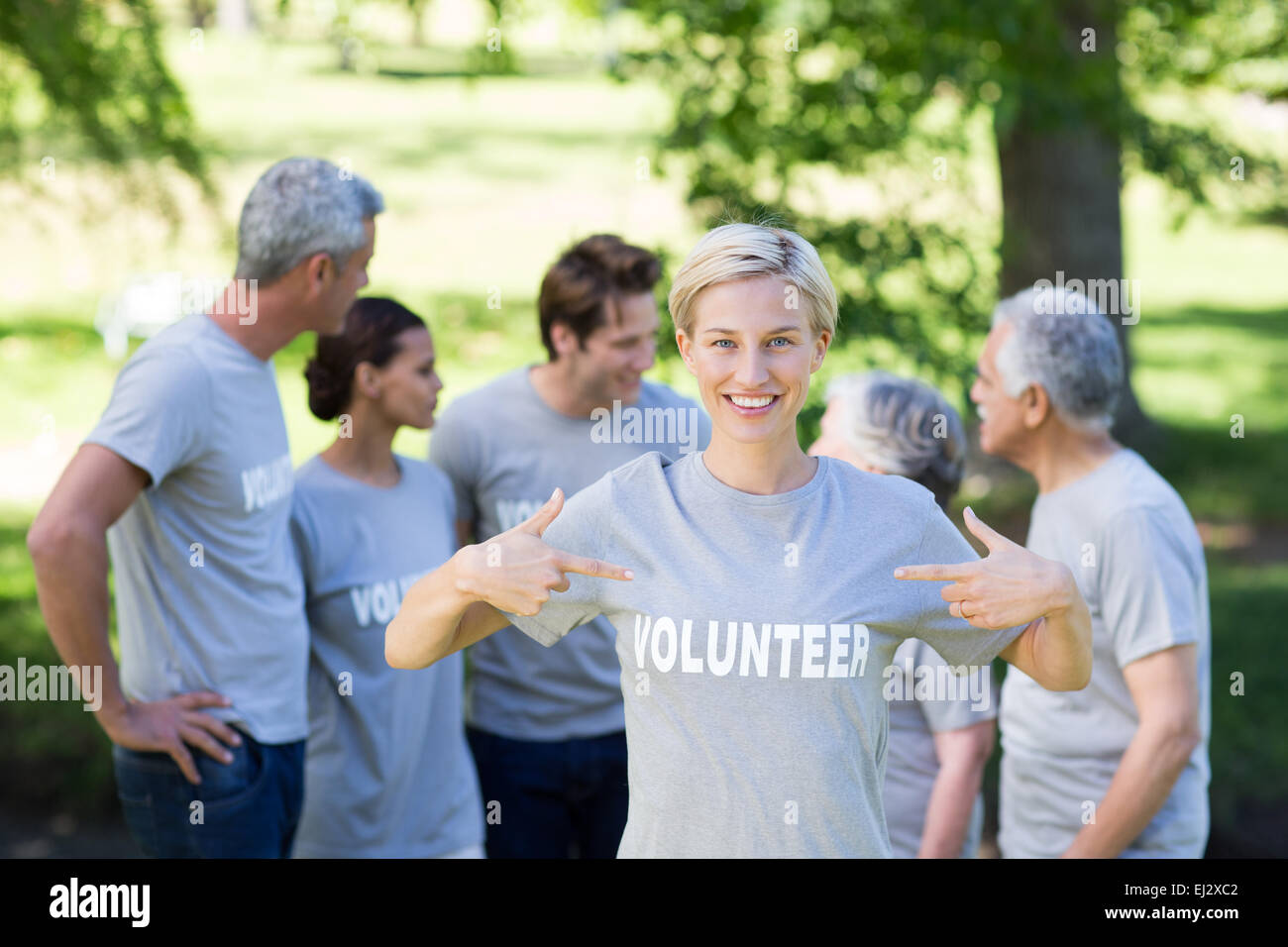 Happy volunteer blonde smiling at the camera Stock Photo - Alamy