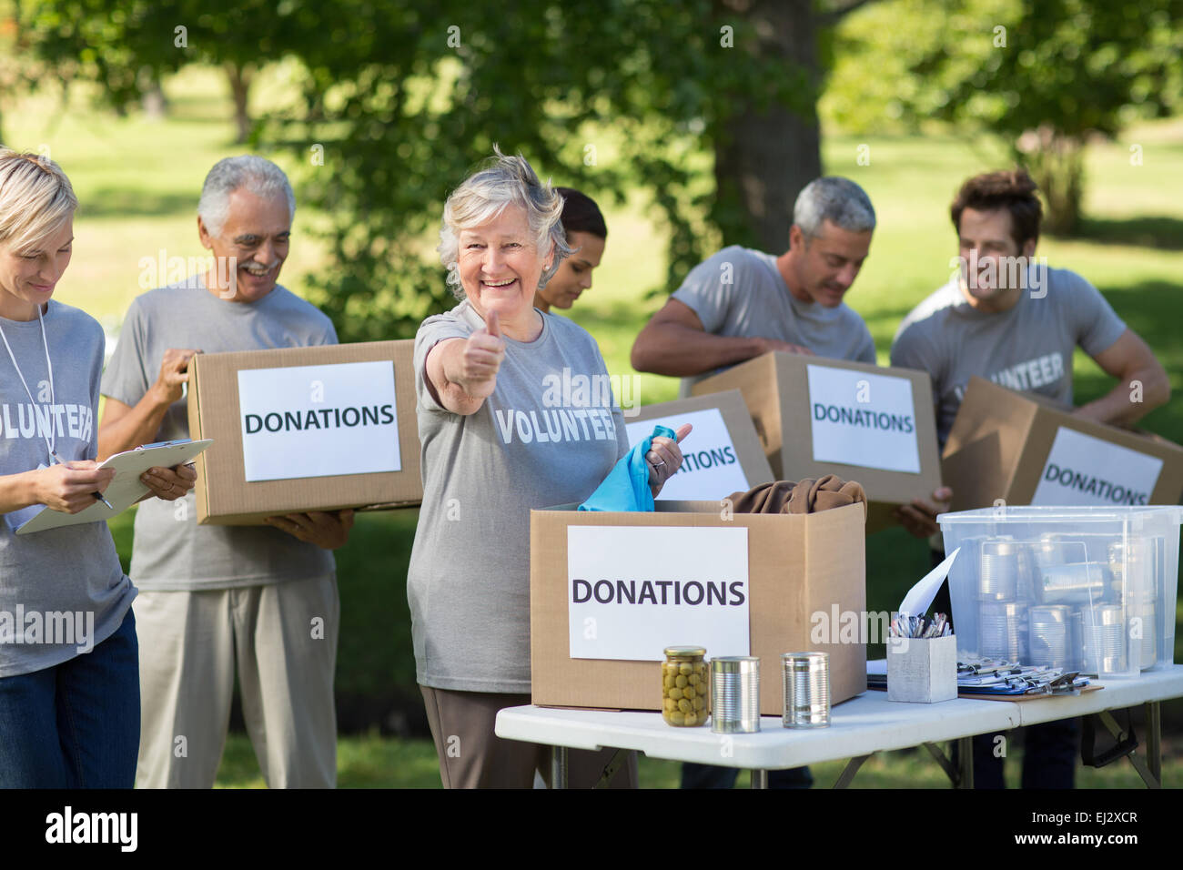 Happy family holding donations boxes with thumb up Stock Photo - Alamy