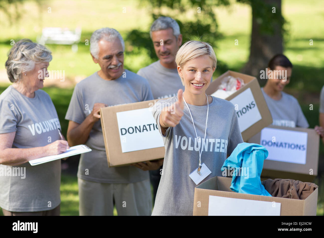 Happy volunteer blonde with thumb up Stock Photo - Alamy