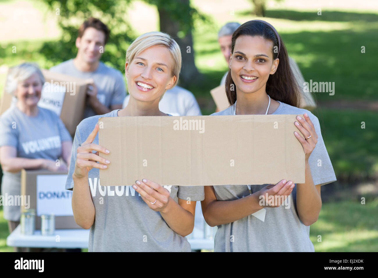 Happy group of friends holding blank sign hi-res stock photography and ...
