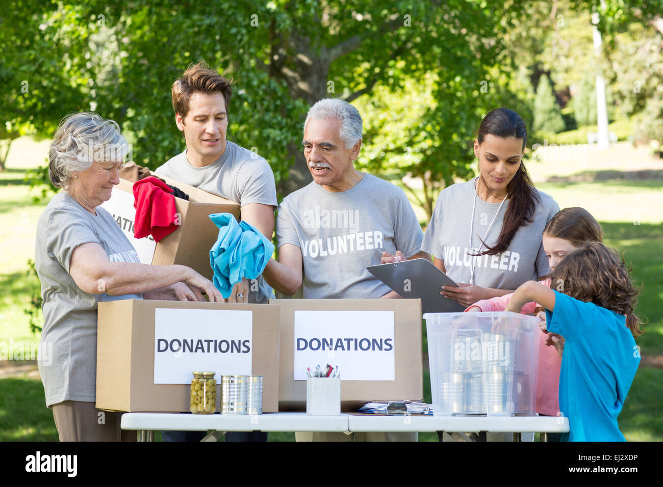 Happy volunteer family separating donations stuffs Stock Photo - Alamy