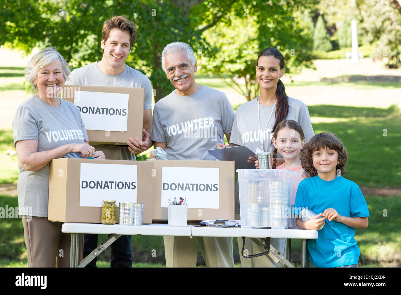 Happy volunteer family separating donations stuffs Stock Photo - Alamy