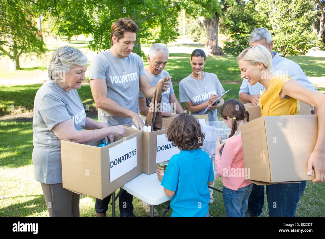 Happy volunteer family separating donations stuffs Stock Photo - Alamy