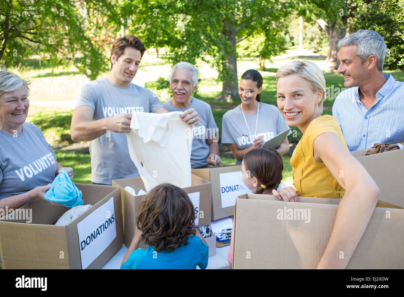 Happy volunteer family separating donations stuffs Stock Photo - Alamy