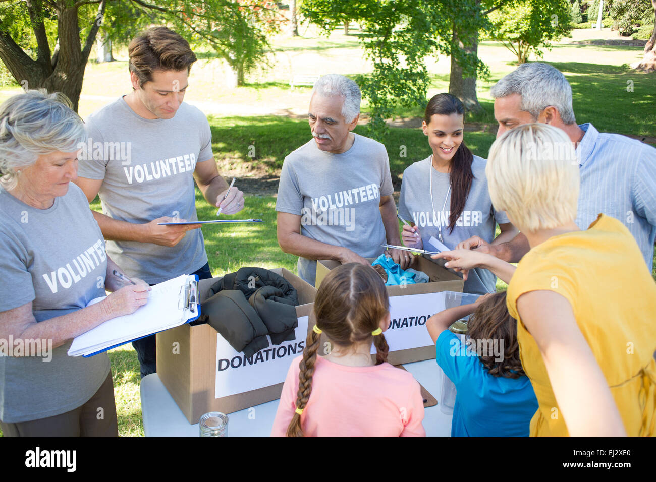Happy volunteer family separating donations stuffs Stock Photo - Alamy