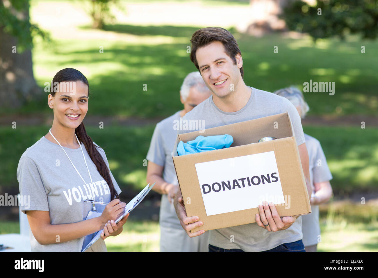 Happy volunteer man holding donation box Stock Photo - Alamy