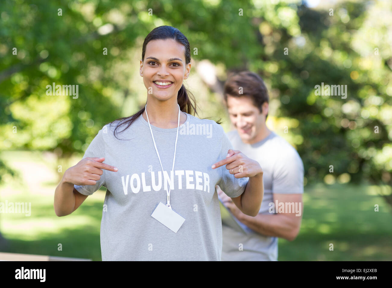 Happy volunteer brunette smiling at the camera Stock Photo - Alamy