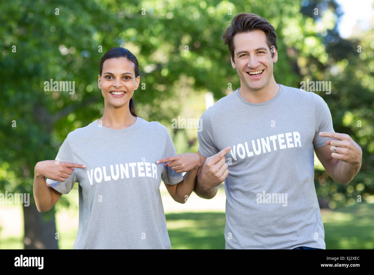 Happy volunteer couple smiling at the camera Stock Photo - Alamy
