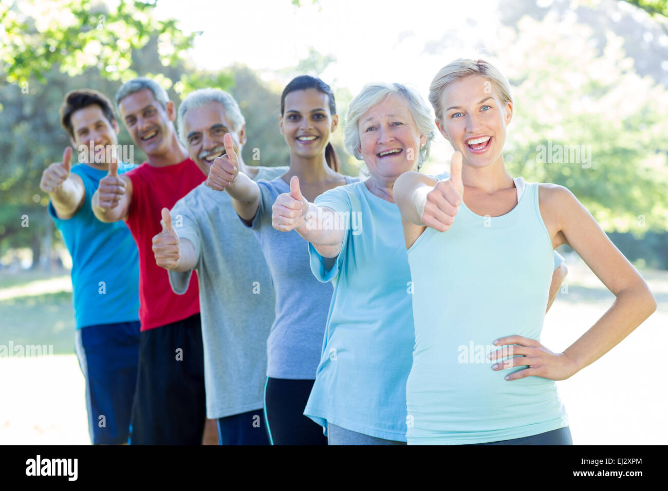 Happy athletic group with thumbs up Stock Photo - Alamy