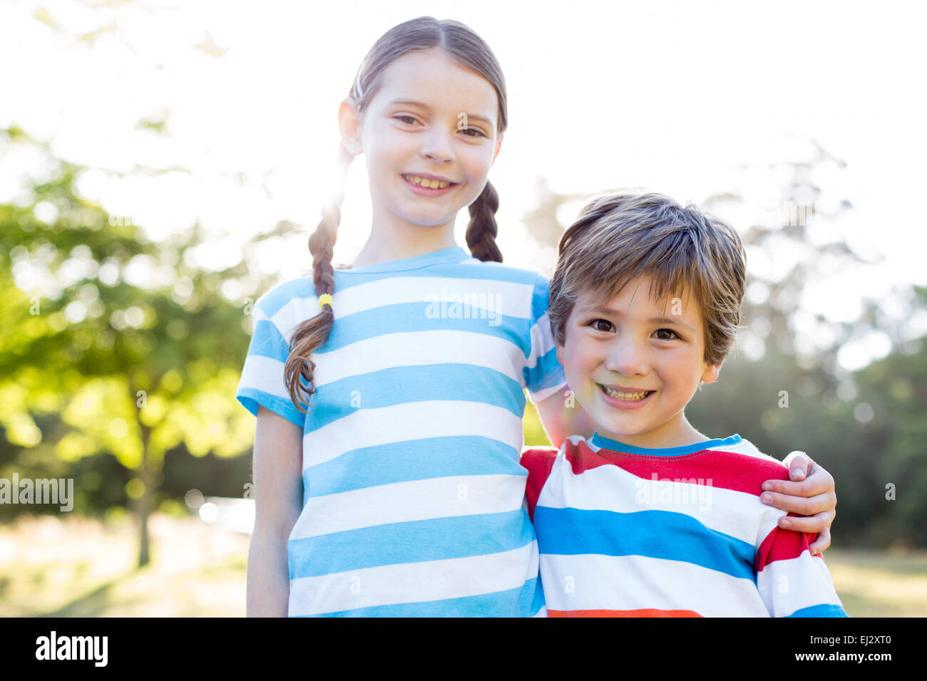 Happy siblings smiling at camera Stock Photo - Alamy