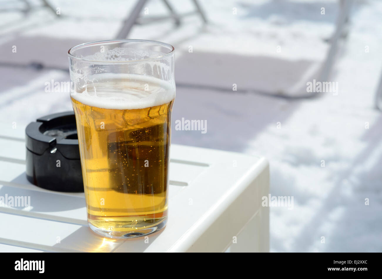Glass of beer on a table on snow Stock Photo - Alamy