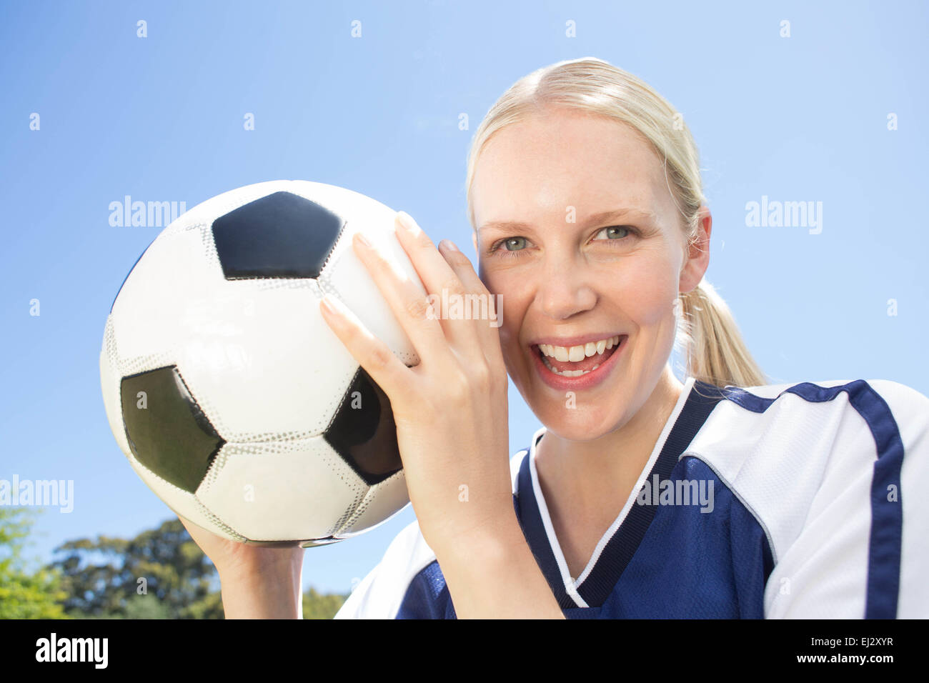 Pretty football player smiling at camera Stock Photo - Alamy