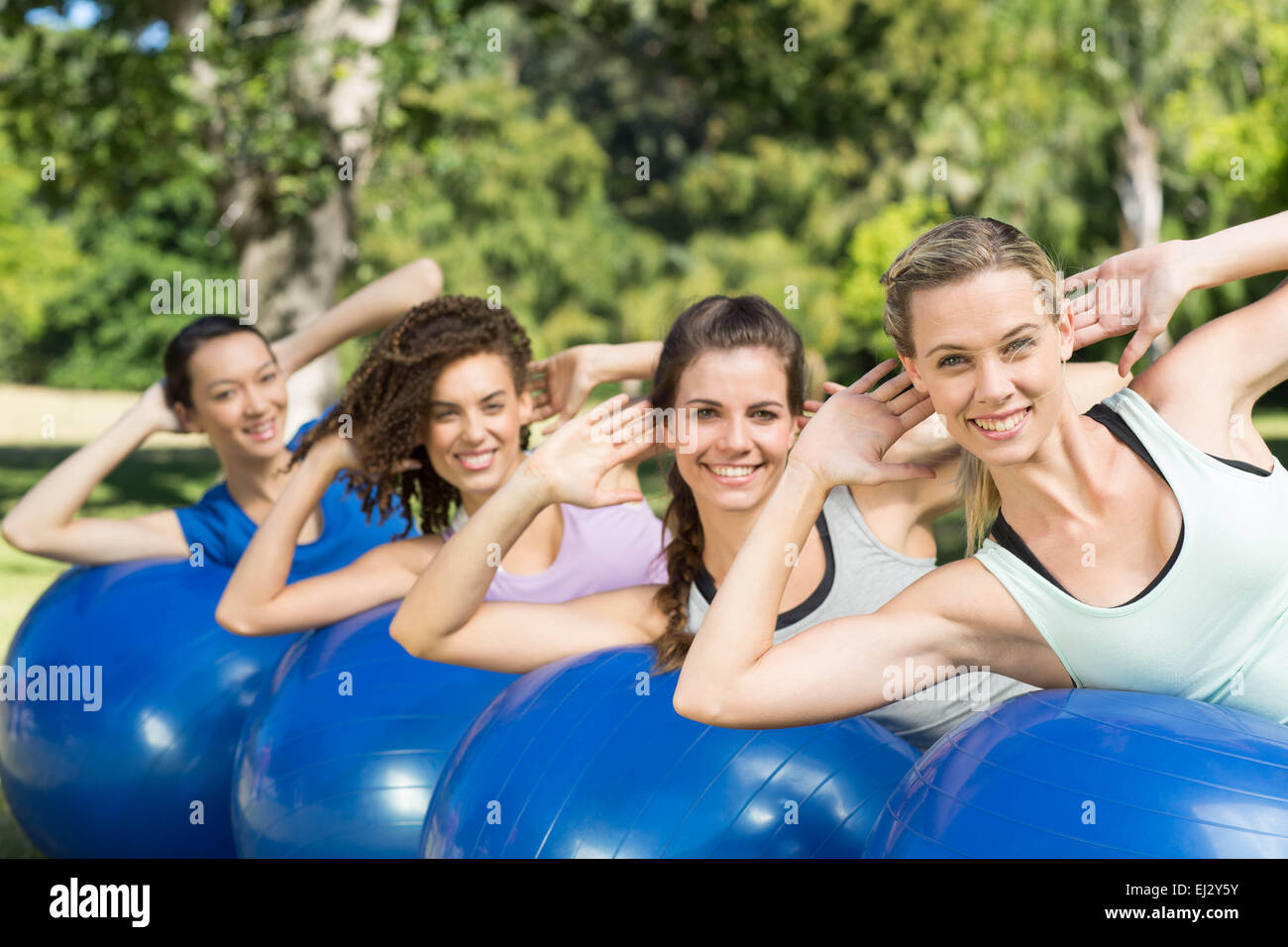 Fitness group using exercise balls in park Stock Photo - Alamy