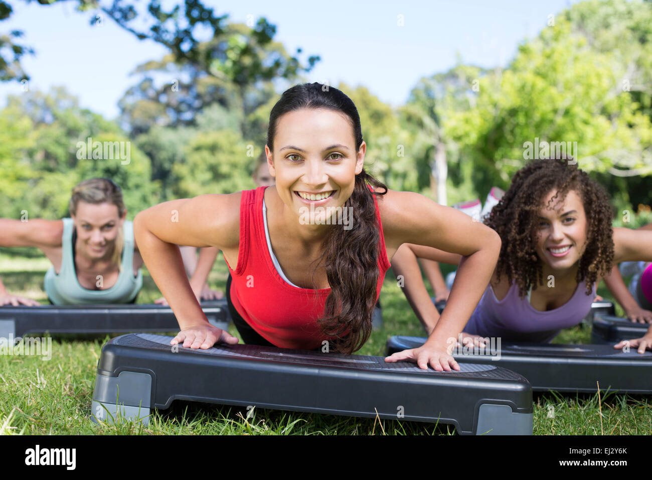 Fitness group using steps in park Stock Photo - Alamy