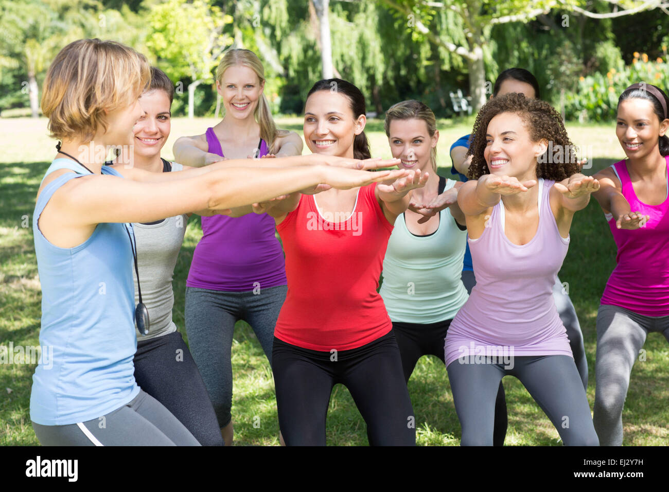 Fitness group warming up in park Stock Photo - Alamy