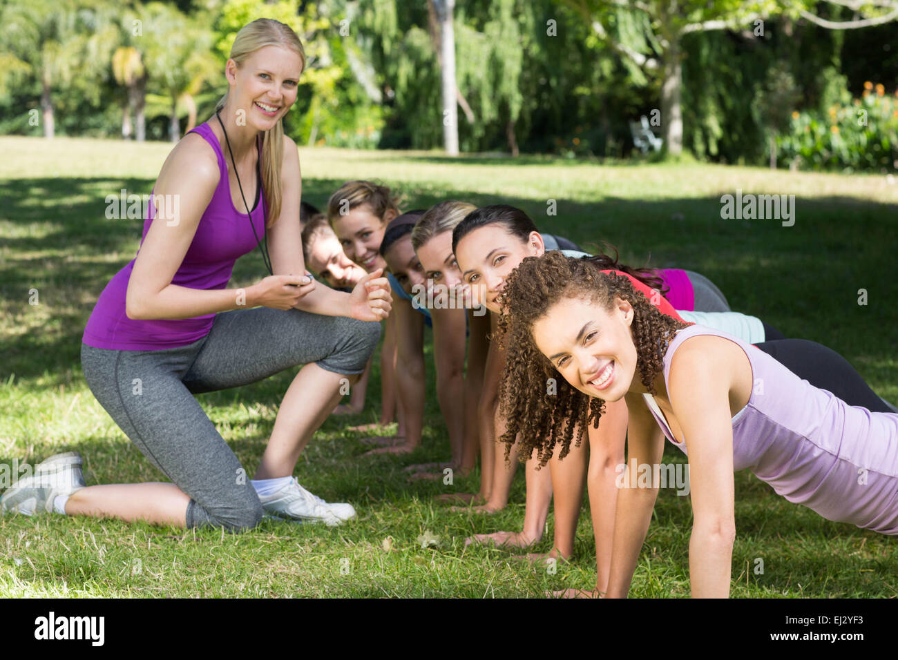 Fitness group planking in park Stock Photo - Alamy