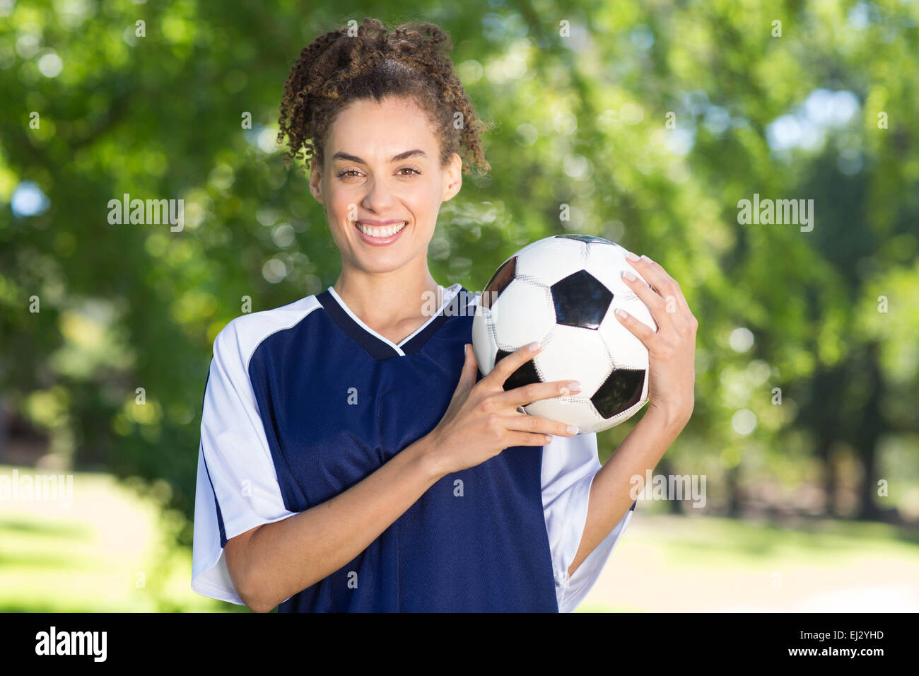 Pretty football player smiling at camera Stock Photo - Alamy