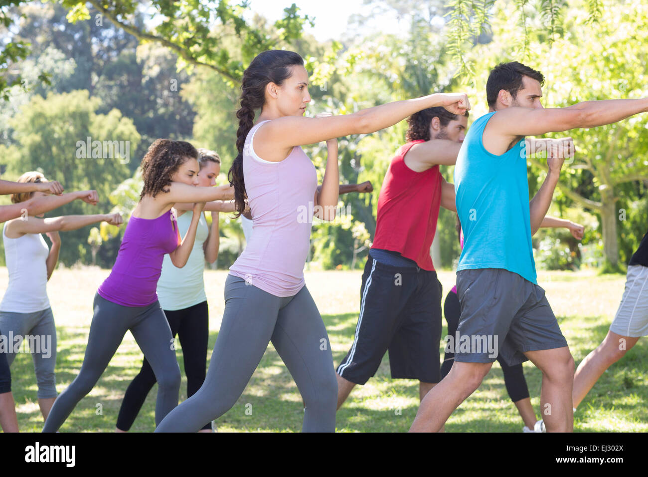 Fitness group working out in park Stock Photo - Alamy