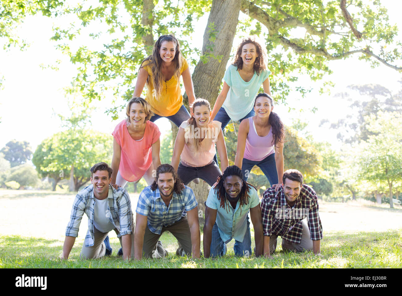Happy friends in the park making human pyramid Stock Photo - Alamy