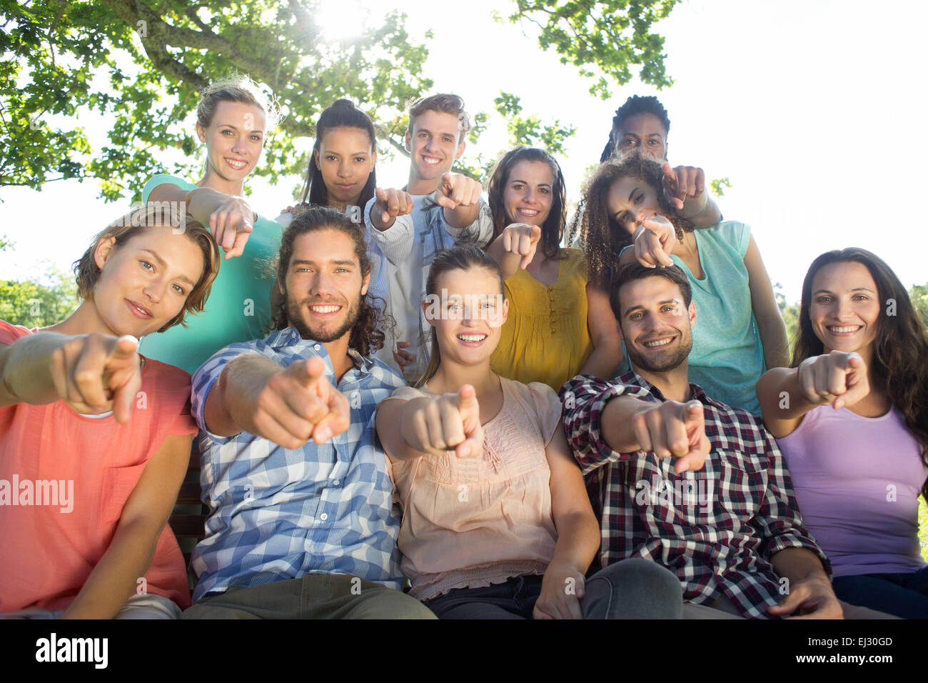 Smiling friends pointing at camera Stock Photo - Alamy