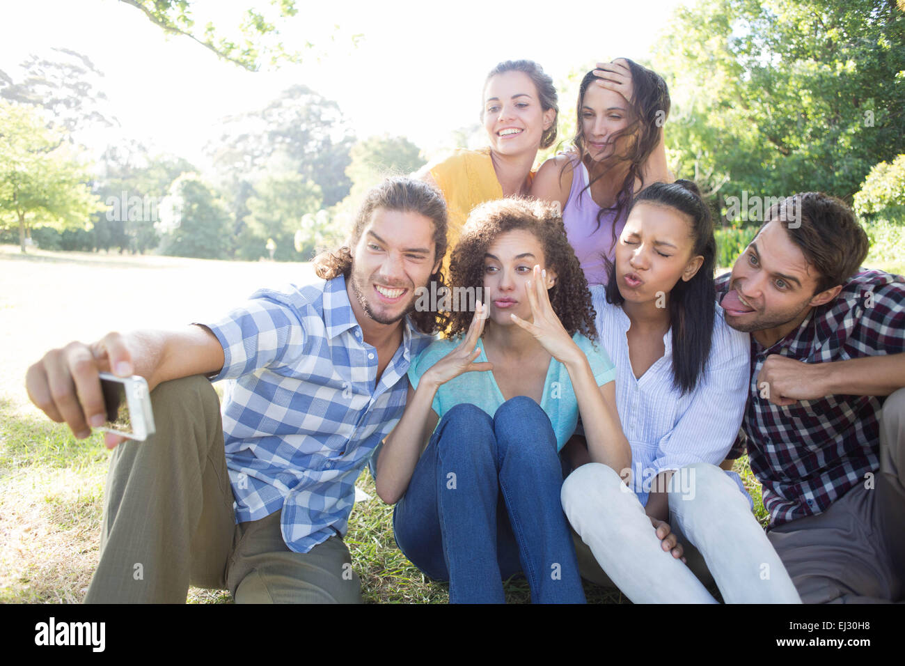 Smiling friends in the park taking selfie Stock Photo - Alamy