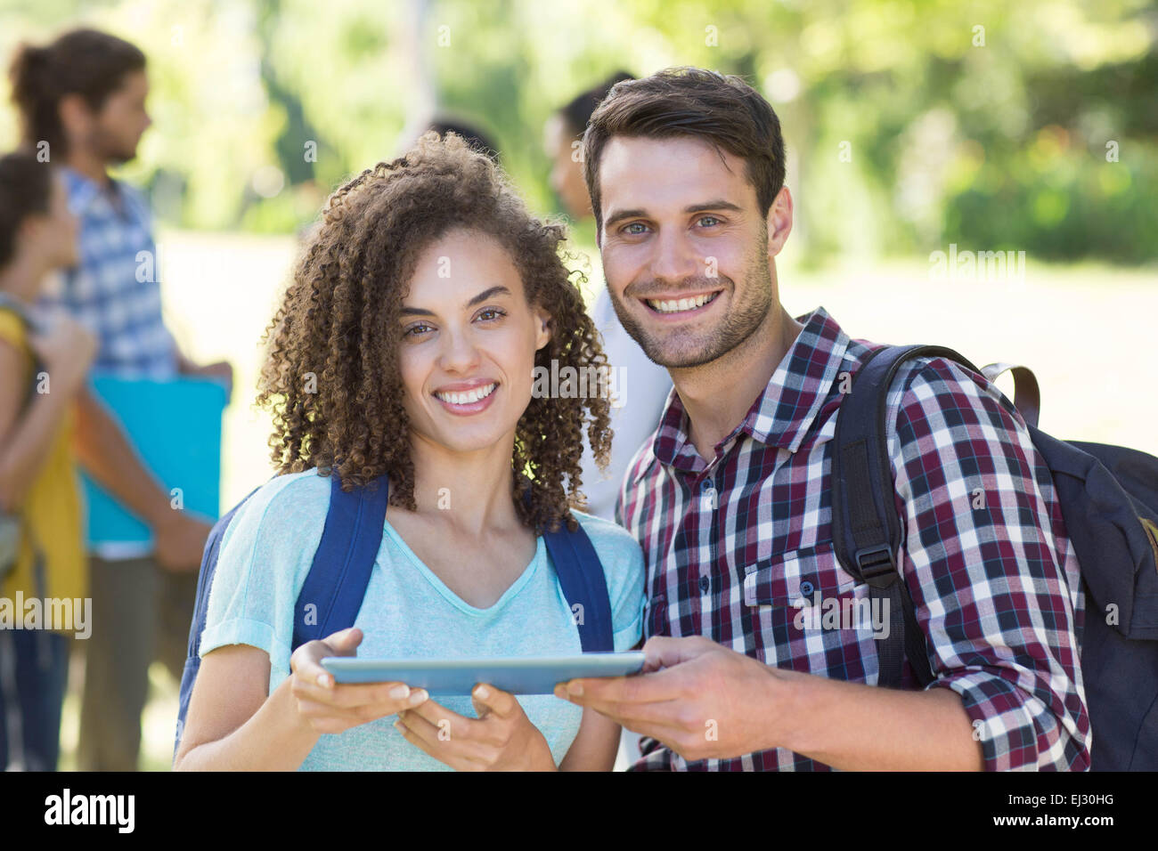 Smiling students using tablet pc Stock Photo - Alamy