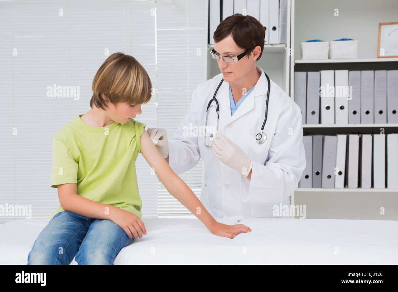 Doctor doing injection at little boy Stock Photo - Alamy