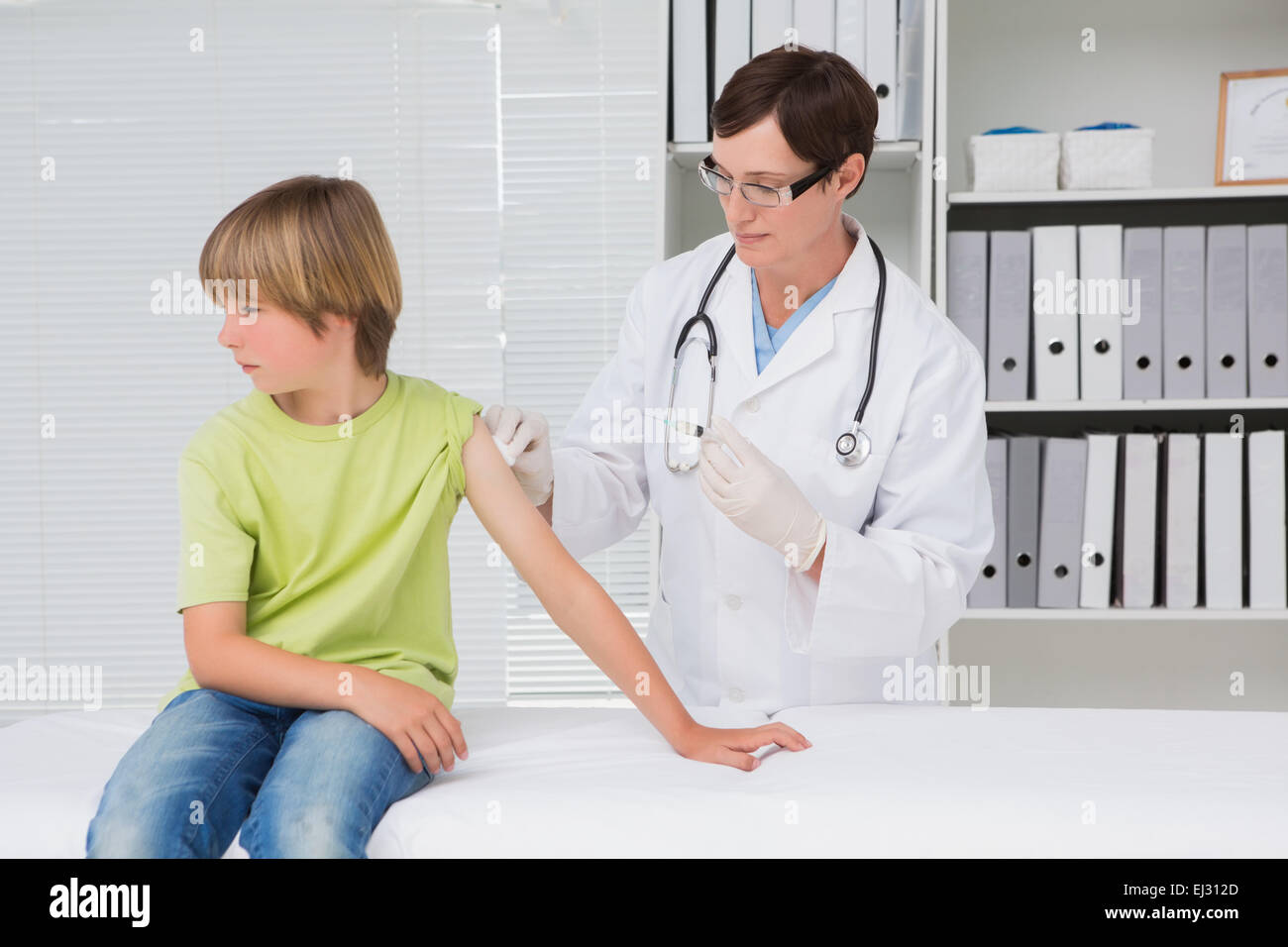 Doctor doing injection at little boy Stock Photo - Alamy