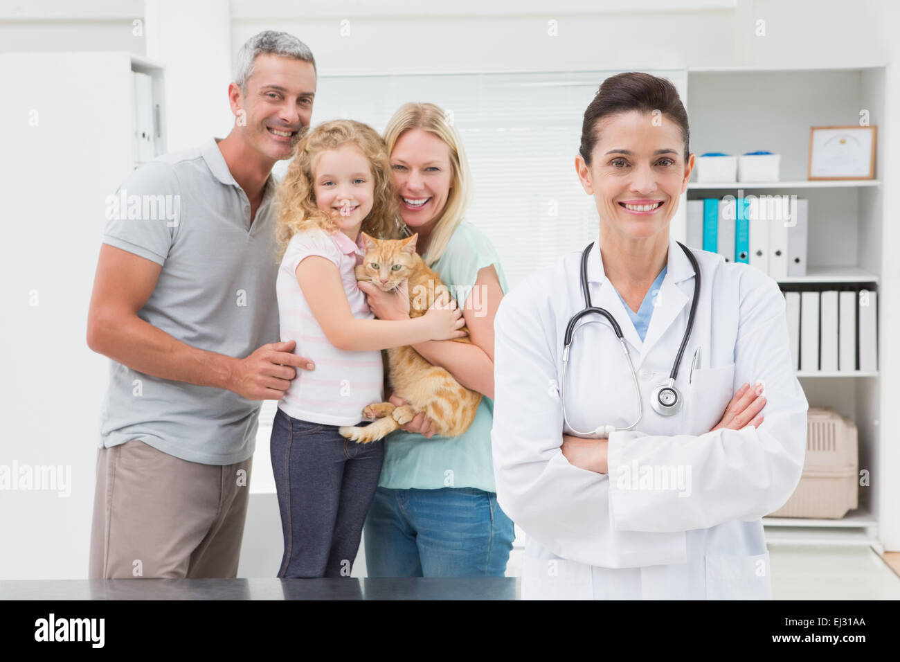 Veterinarian and cat owners smiling at camera Stock Photo - Alamy
