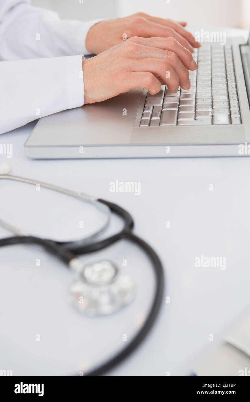 Doctor using laptop near stethoscope Stock Photo - Alamy