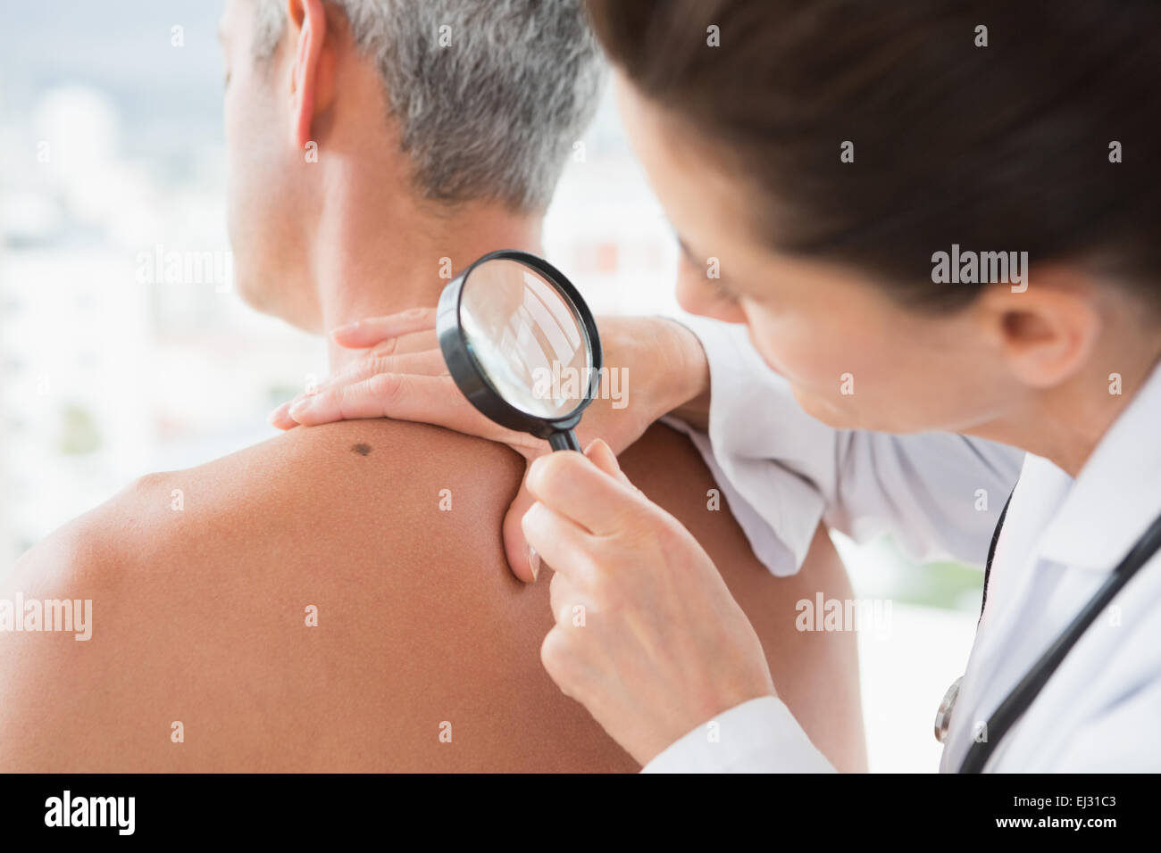 Doctor examining patient with magnifying glass Stock Photo - Alamy